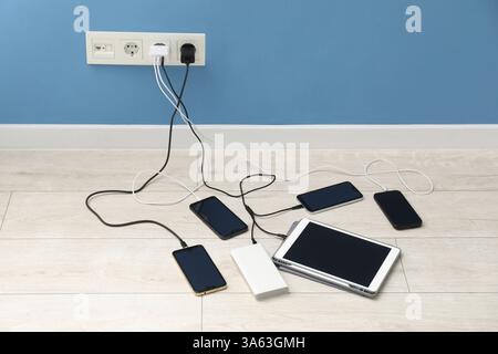 USB adapters with cables plugged into electric socket charging ...