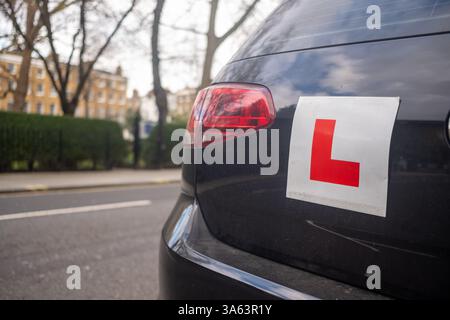 UK- Learner driver L plates attached to car on urban road in the UK ...