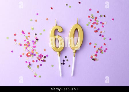 60th birthday. Number shaped candles and confetti on violet background ...