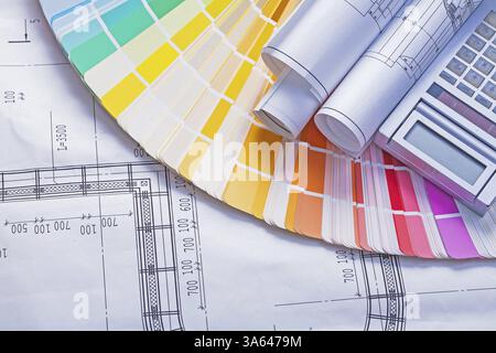 rolled bueprints and calculator on color palette Stock Photo - Alamy