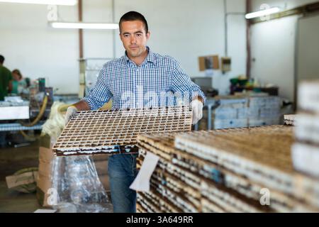 Man carrying cell seed trays in agricultural facility Stock Photo - Alamy