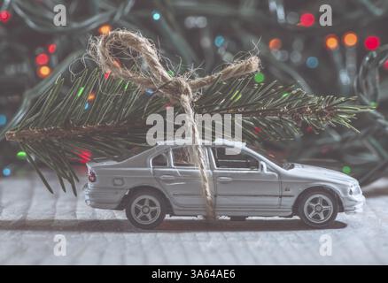 Toy car with small Christmas tree on green background Stock Photo - Alamy