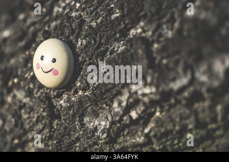 Smile icon miniature on tree twig Stock Photo - Alamy