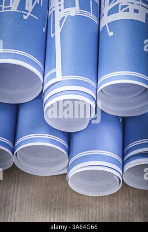 Composition of blue rolled up construction drawings on grey background ...