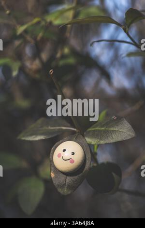 Smile icon miniature on tree twig Stock Photo - Alamy