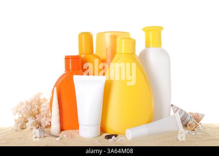 Different sun protection products, coral and seashells on sand against ...