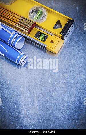 Wooden meter blue rolled construction plans level on metallic ...
