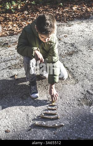 Child make pine tree of wooden sticks Stock Photo - Alamy