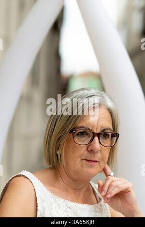 Attractive woman in glasses deep in thought Stock Photo - Alamy