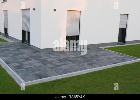 Laying slabs on a garden terrace, building a veranda, a floor made of ...