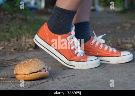 Good bye junk food hamburger left to jogging exercise Stock Photo - Alamy