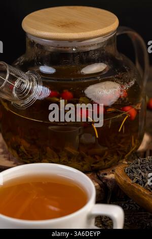 Dried rose in a cup of hot tea on a black background Stock Photo - Alamy