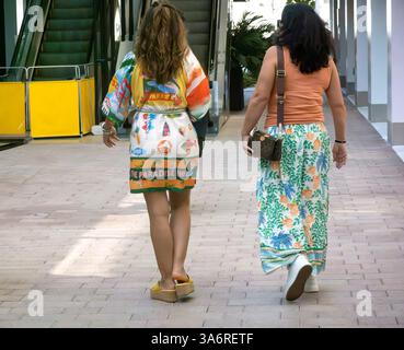 Two women friends walking and talking in a modern shopping mall Stock ...