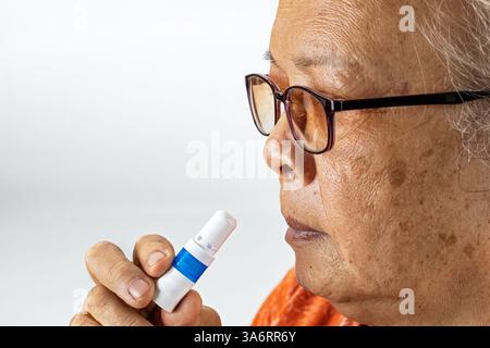 Inhaler Therapy: Anxious Senior Asian Woman Carefully Inserts Two ...