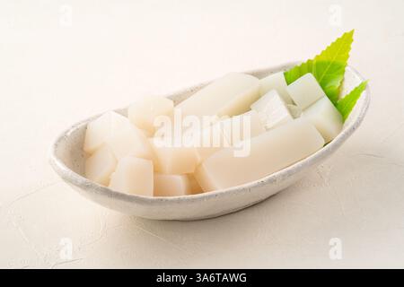 Raw konjac in square shape in a plate on white table background, also ...