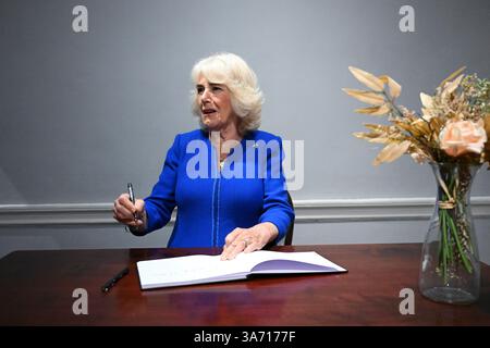 Queen Camilla signs the guest book during a visit to St Mungo's in ...