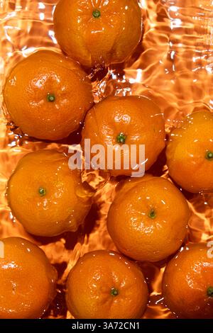 Vibrant tangerines in water splash frozen in time Stock Photo - Alamy