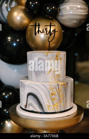 A stunning marble cake with gold accents and a black 30 topper for a ...