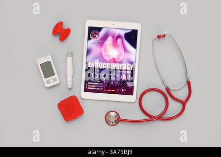 Tablet computer with thyroid gland model, glucometer and stethoscope on ...