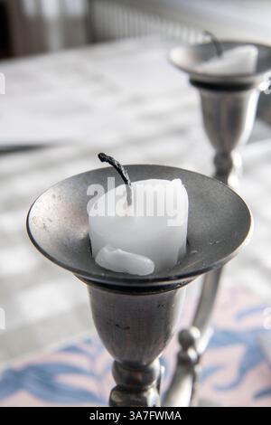 Stump of stearin candle with black-fired wick in metal candlestick ...