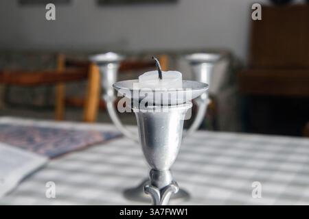 Stump of stearin candle with black-fired wick in metal candlestick ...