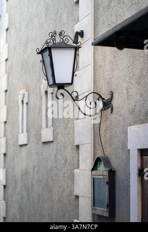 A vintage-style street lamp illuminating the side of an old brick ...