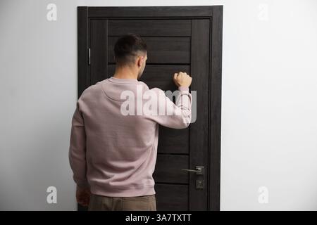Man knocking on apartment door, closeup view Stock Photo - Alamy