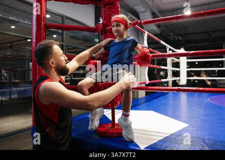 Coach encouraging girl in boxing ring corner Stock Photo - Alamy