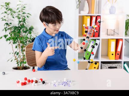 Boy showing DNA structure model at desk indoors Stock Photo - Alamy