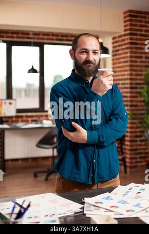 Businessman holding paper with charts near multiethnic colleagues and ...