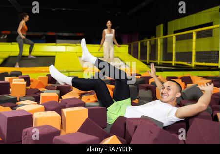 Cheerful young man jumping into foam pit at trampoline park Stock Photo ...