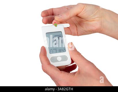 Person holds a blood glucose meter displaying a reading, ensuring ...