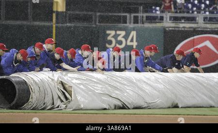 Ground crew members cover the field before the MLB baseball All-Star ...