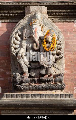 Ganesha Statue with Marigold Garlands. A stone statue of Ganesha under ...