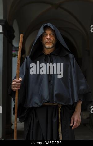 Medieval monk in hooded cloak praying in the dark Stock Photo - Alamy
