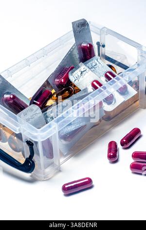 Plastic container with various pills on a blue background. Planning the ...