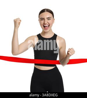 Happy sportswoman crossing red finish line ribbon on white background ...