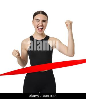 Happy sportswoman crossing red finish line ribbon on white background ...