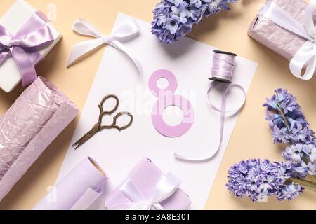 Figure 8 with lilac flowers, gift boxes and wrapping paper on beige ...