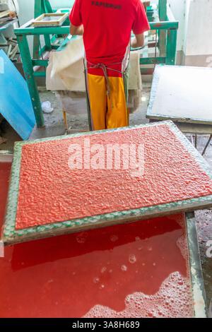 A Filipino man makes handmade paper inside a handicraft shop in Kalibo ...