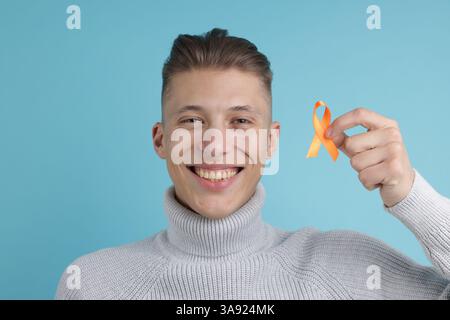 Man with light blue ribbon on color background with space for text ...