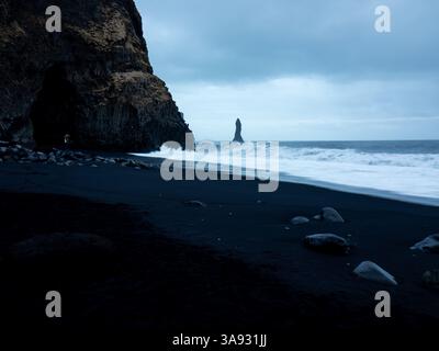 Reynisfjara Beach at dusk with rugged basalt columns and Reynisdrangar ...