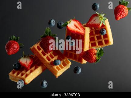 Waffles with blueberries and strawberries. Food levitation Stock Photo ...