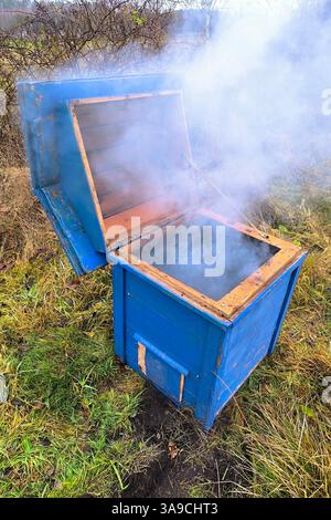 Detail of a burning beehive in an apiary. Chemical treatment and ...