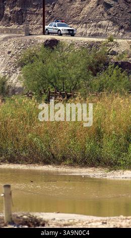 A border patrol vehicle sits in hiding by the U.S.-Mexican border wall ...