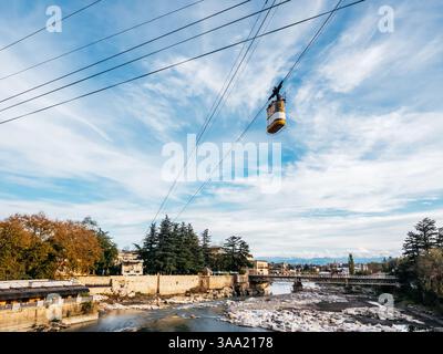 Yellow cable cars, cableway over the bridge, Rioni river and city blue ...