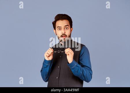 Amazed handsome man in glasses, holding cute black pug dog on shoulder ...