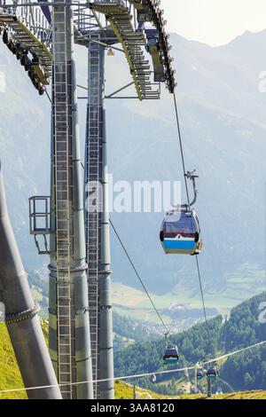 Scenic cable car glides lush valley with towering metal columns along ...