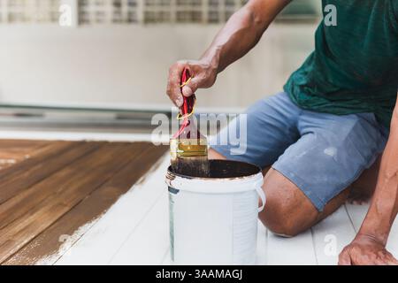Hand holding paint bush painting anti rust paint on steel at home ...