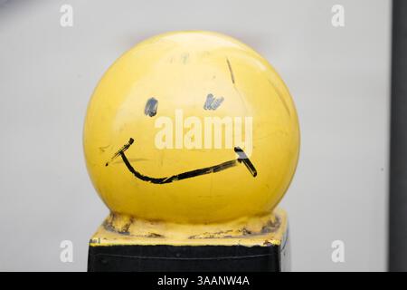 A smiley face is seen drawn with marker on the tip of a bollard in ...
